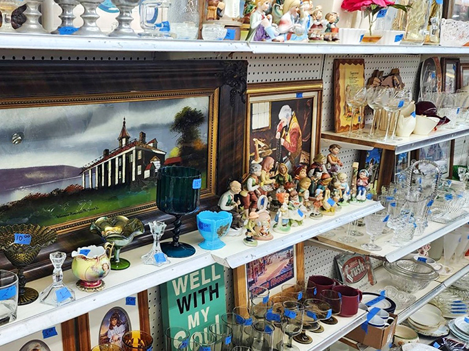 A treasure hunter's dream shelf—where Mount Vernon paintings neighbor Hummel-inspired figurines and depression glass catches the light.