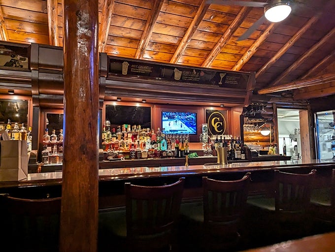 The bar gleams with amber bottles and polished wood—a place where Manhattan cocktails meet wilderness lodge in perfect harmony.