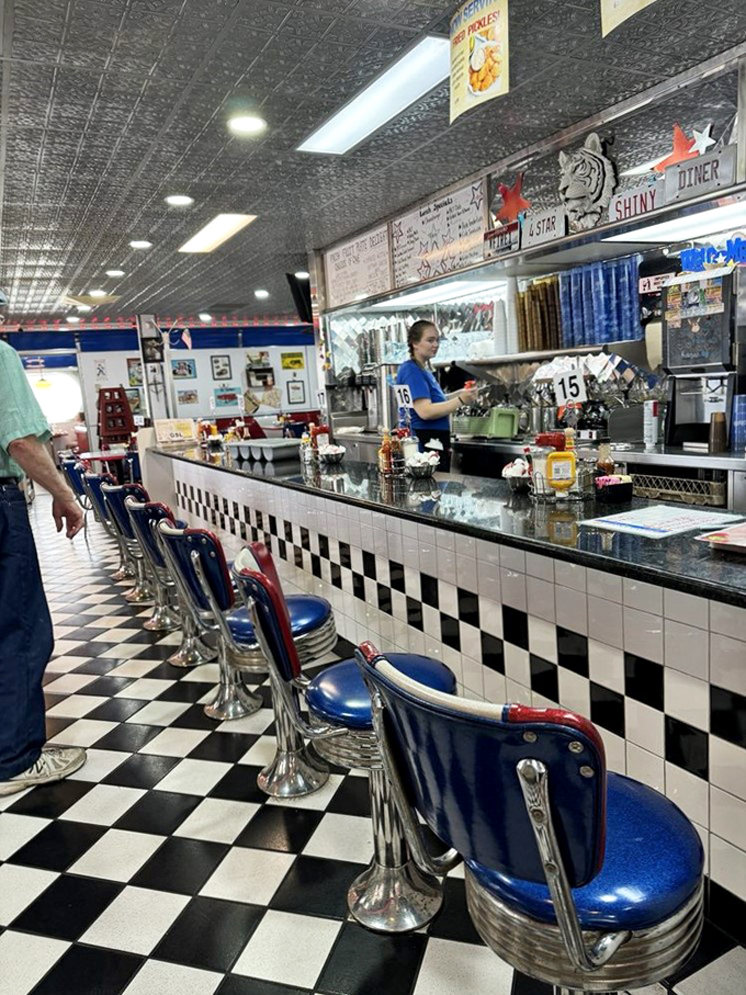 The counter where regulars have worn their own invisible nameplates into the seats, a front-row view to short-order magic.