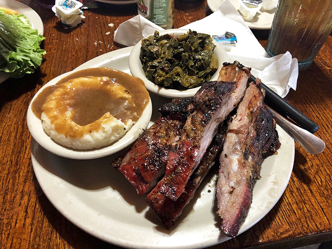 BBQ ribs with that perfect smoke ring, tender mashed potatoes, and collard greens—the holy trinity of Southern comfort on a plate.