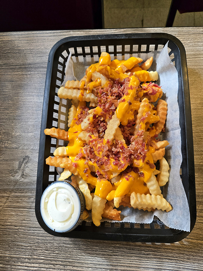 Loaded fries that require both a fork and a strategy—each bite delivering the perfect ratio of crispy potato, melty cheese, and bacon bits.
