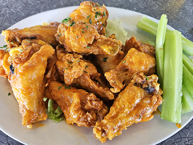 Wings that don't need a sports bar to shine. Glistening with sauce and paired with celery sticks—nature's way of pretending you're eating something healthy too.