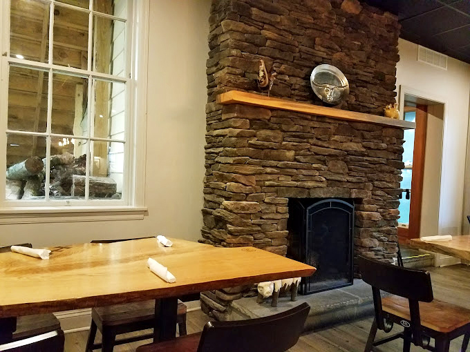 That stone fireplace isn't just decoration—it's a monument to the primal connection between fire, stone, and perfectly smoked meat.
