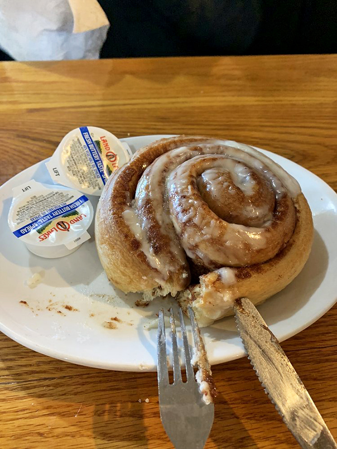 This cinnamon roll isn't just breakfast—it's dessert masquerading as a morning meal, and nobody's complaining about the deception.