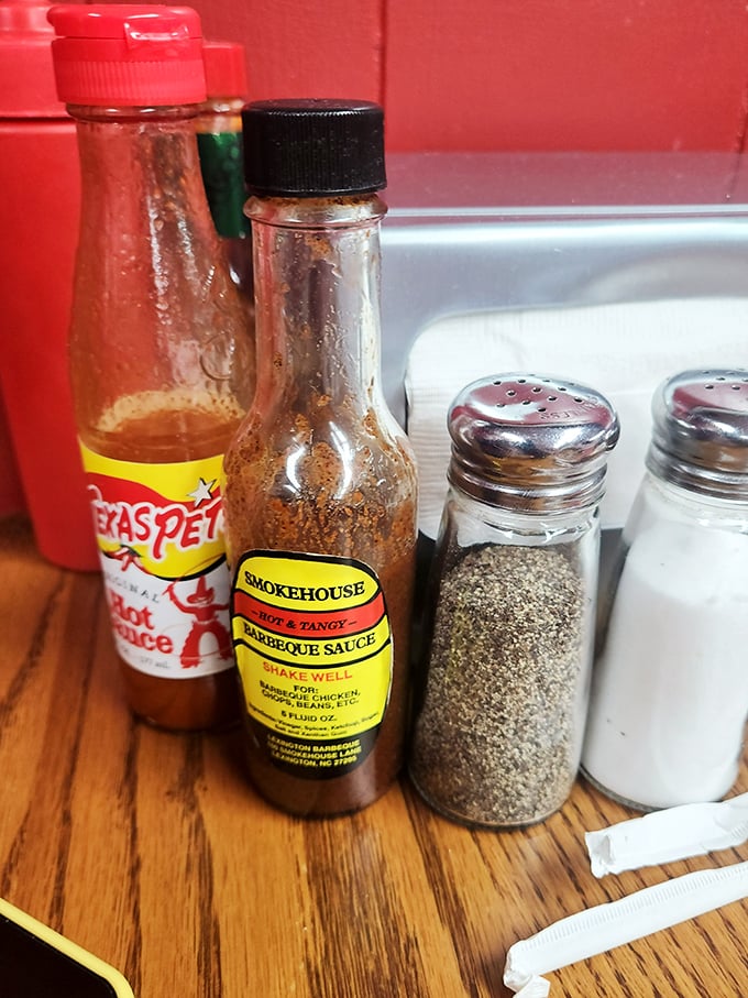 The holy trinity of barbecue condiments – hot sauce, tangy barbecue sauce, and the essential salt and pepper for personal customization.