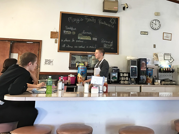 The counter where breakfast magic happens—where orders are called, coffee is poured, and the rhythm of small-town life plays out daily.