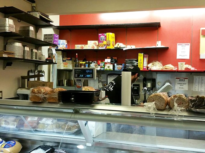 The counter view reveals the behind-the-scenes magic—fresh breads waiting their turn while staff members orchestrate the daily symphony of sandwiches.