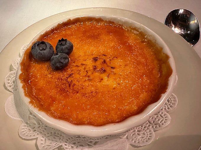 Crème brûlée with the perfect crack—like breaking thin ice on a puddle, but infinitely more delicious. Those blueberries aren't just garnish, they're little flavor bombs.