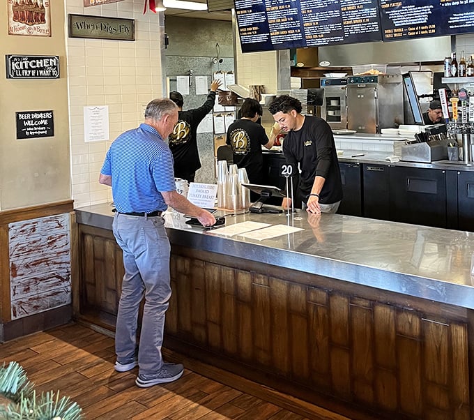 Customers lean in with the focus of scholars studying ancient texts—except these texts are menus.