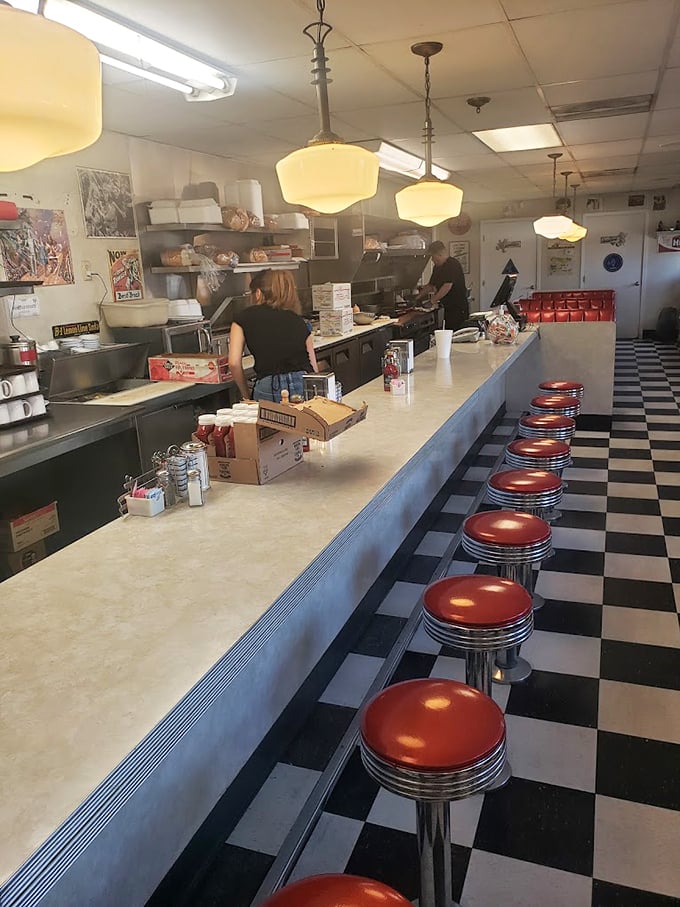 Those red counter stools aren't just seating—they're front-row tickets to the greatest show in town: breakfast being made right.