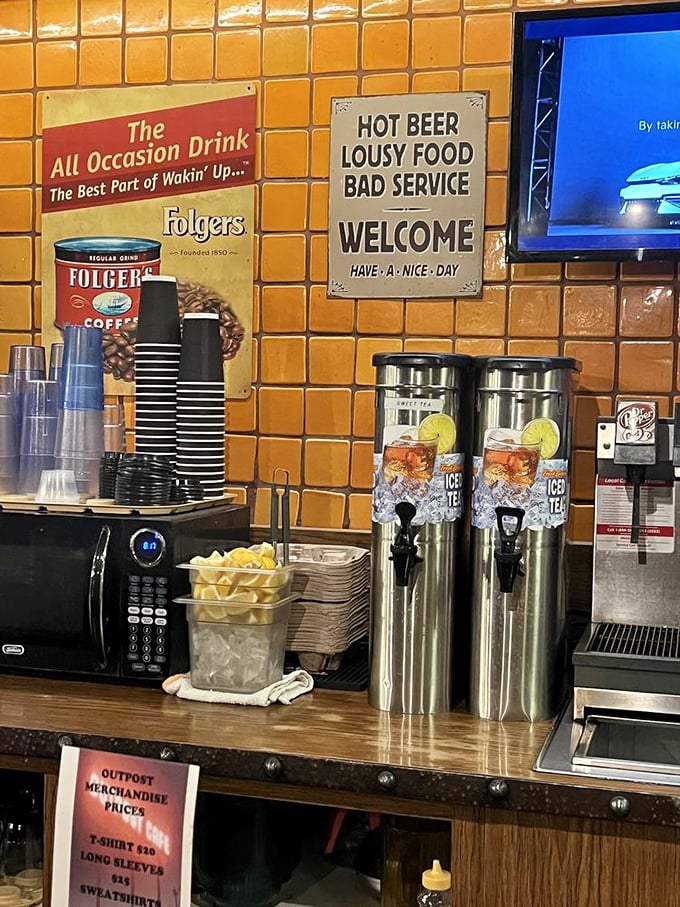 Even the drink station has personality—where "Hot Beer, Lousy Food, Bad Service" signs reveal the self-deprecating humor that confident kitchens can afford.