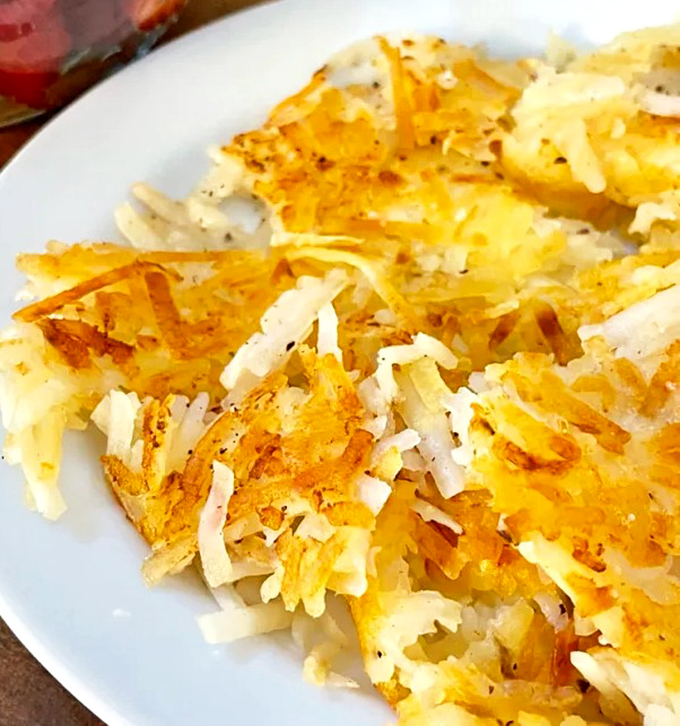 Hash browns with the perfect crisp-to-tender ratio. That golden crust is what breakfast dreams are made of—simple perfection on a white plate.