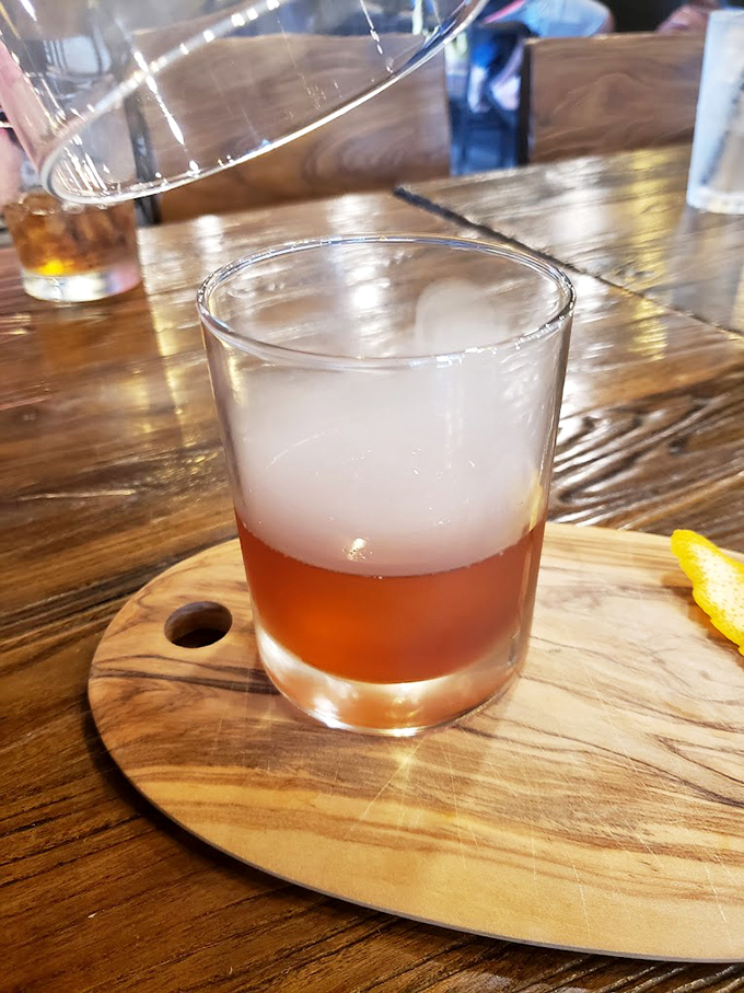 A cocktail served on a wooden board – because in 2023, regular coasters are so last decade.