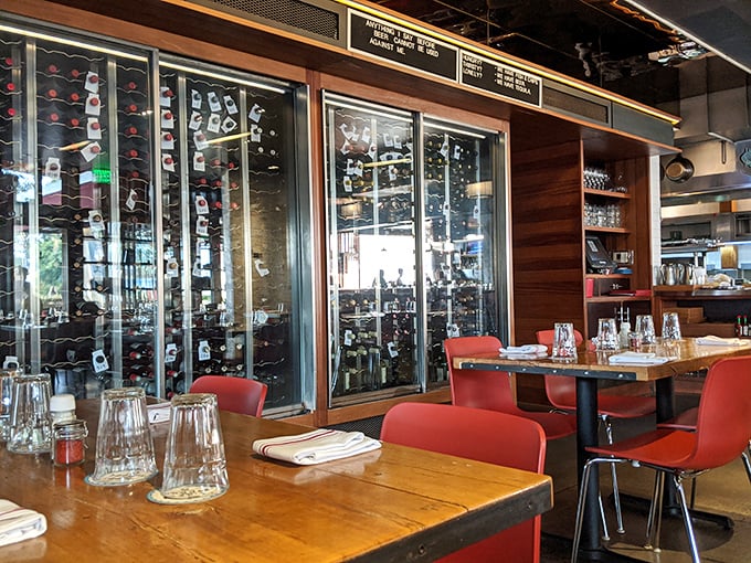 The warm wooden tables against those bright red chairs create the perfect stage for seafood drama. That wine display isn't just storage—it's a promise.