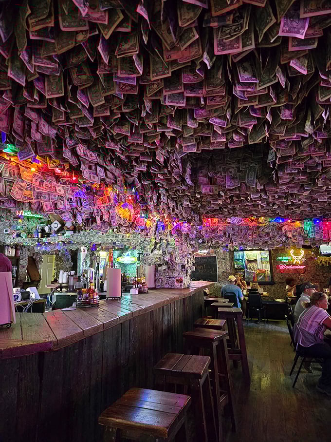 The dollar-bill decor glows under string lights like a cave of currency wonders—each bill a story, each signature a memory made.