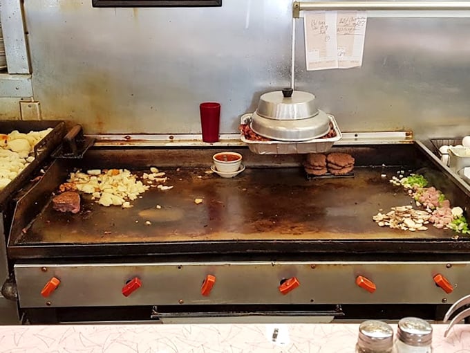 The flattop grill—hallowed ground where breakfast dreams materialize from sizzling choreography and decades of short-order wisdom.