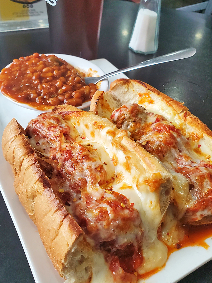 This meatball sub isn't just a sandwich—it's an engineering marvel of melted cheese, marinara, and perfectly seasoned meatballs. The side of baked beans is a bonus.