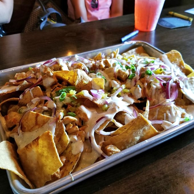 Loaded nachos that laugh in the face of portion control – a mountain of crispy chips, tender meat, and creamy sauce that demands to be shared.