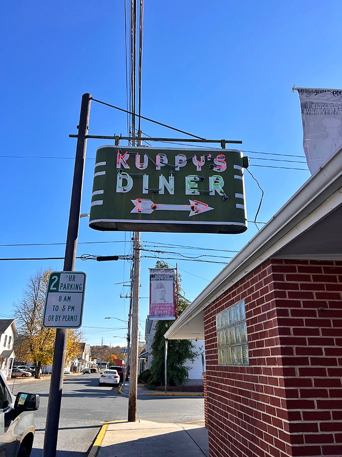 The vintage neon sign glows like a beacon for hungry travelers – part roadside Americana, part "follow me to happiness" arrow.