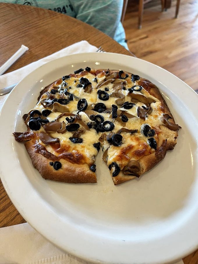 Pizza that knows exactly what it wants to be. That puffy crust loaded with mushrooms, olives, and melty cheese speaks the universal language of satisfaction.