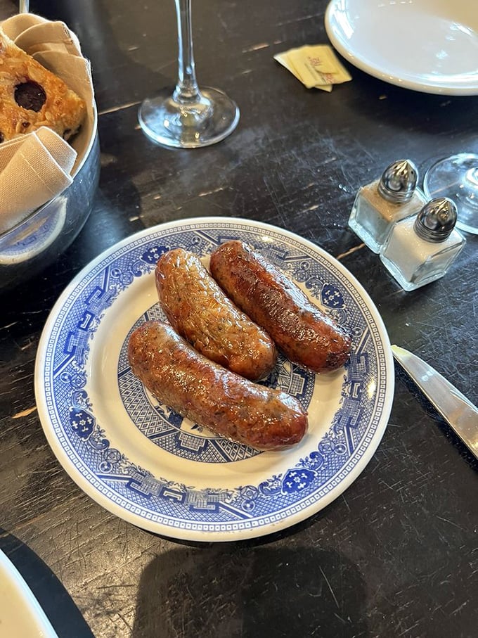 Sausages served on blue willow china—a delightful clash of rustic and refined. Comfort food dressed for a special occasion.