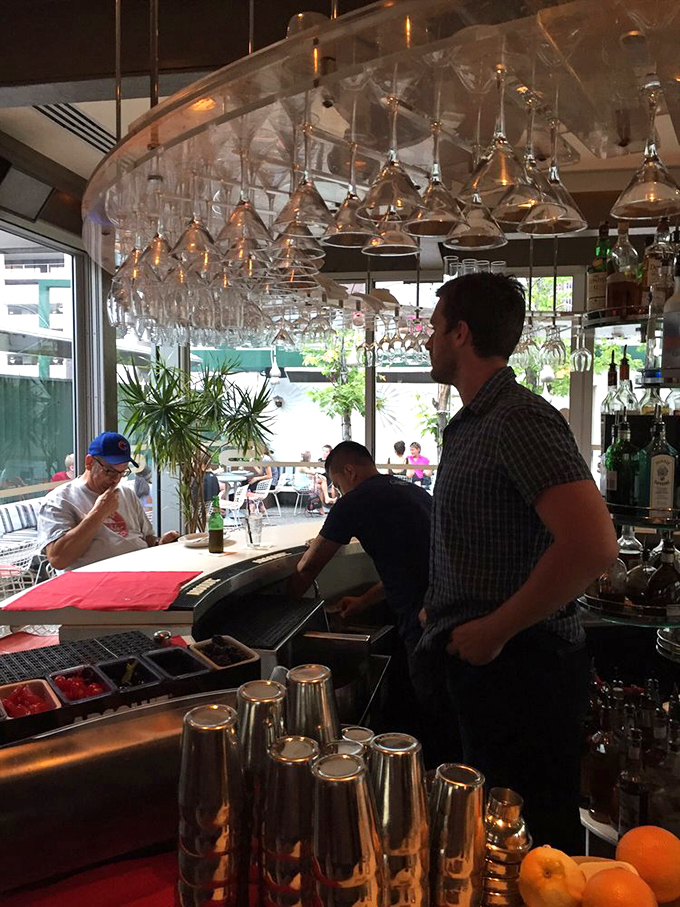 Where the magic happens – the bar area combines sleek design with serious cocktail craftsmanship under a canopy of hanging martini glasses.