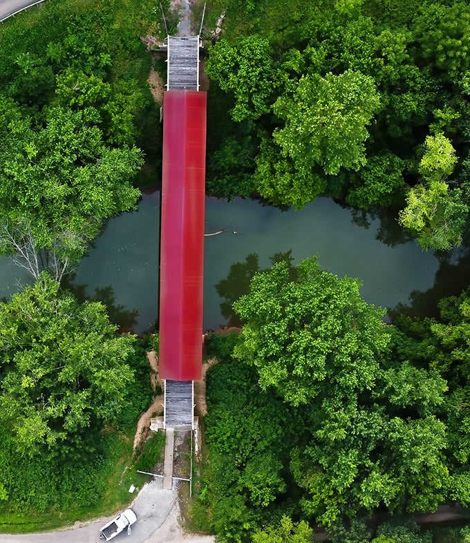 The bird's-eye view reveals how perfectly this human creation nestles into nature's embrace—a crimson brushstroke across a canvas of green.