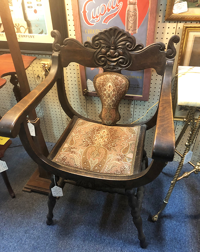 This carved chair isn't just furniture; it's a throne with stories to tell. That face in the woodwork has opinions about your posture.