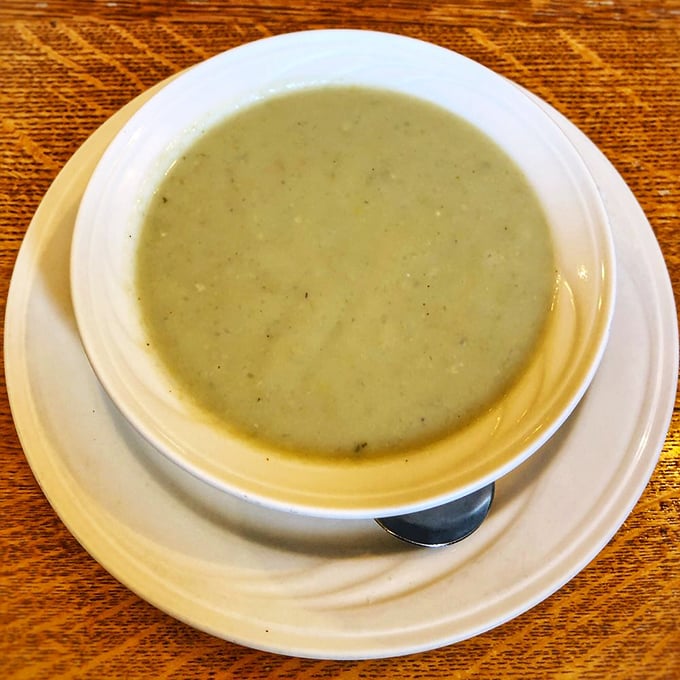 The legendary artichoke soup—a pale green promise of creamy, earthy flavors that captures the essence of coastal California in every spoonful.