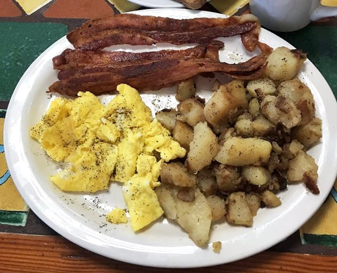 The breakfast trinity—golden eggs, crispy bacon, and home fries seasoned by angels. This plate doesn't need a fancy name to be legendary.