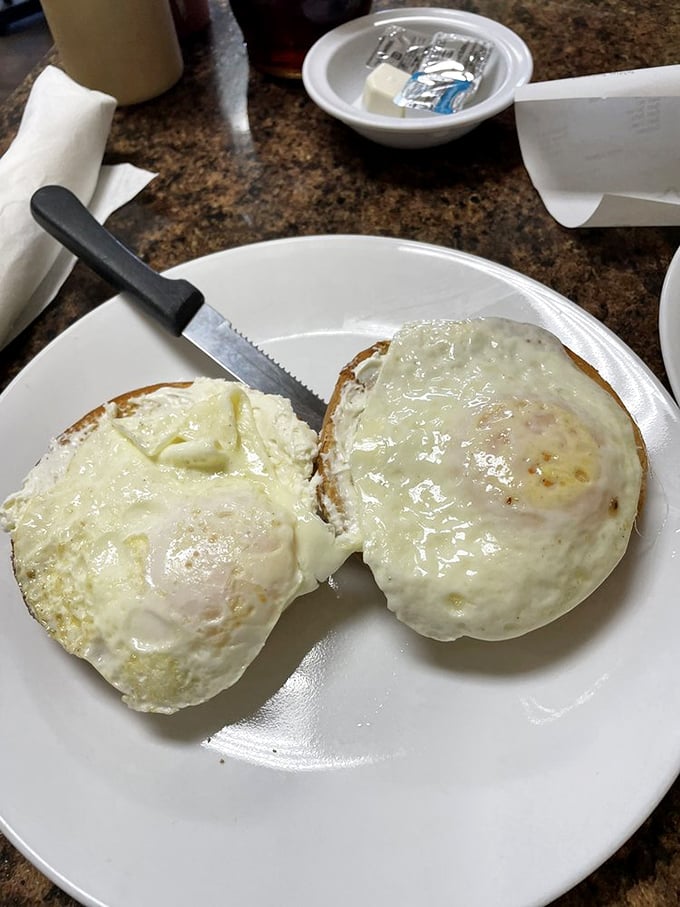 Two perfectly cooked eggs – sunny side up and ready for their close-up – sitting atop what might be the most photogenic English muffin in Naples.