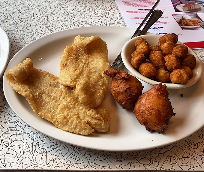 Golden-fried catfish that shatters with each bite, paired with hushpuppies that somehow manage to be both airy and substantial.
