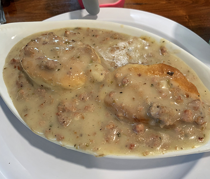 Biscuits swimming in creamy sausage gravy—the kind of dish that makes you want to hug the cook and schedule a treadmill session.