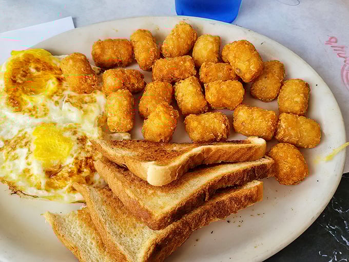 Breakfast perfection on a plate. Those golden tater tots huddle together like tiny potato soldiers guarding your morning eggs.