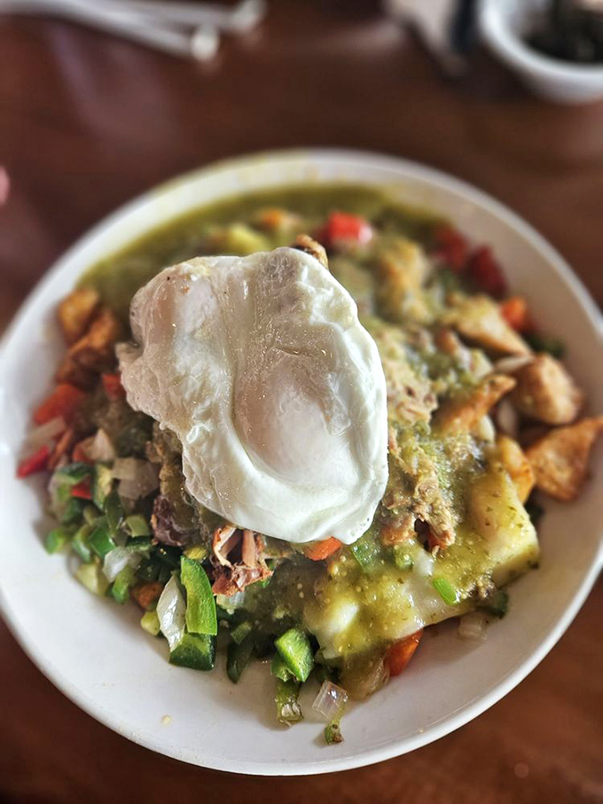 The carnitas skillet arrives like a breakfast rebellion—traditional morning ingredients mingling with Mexican flavors under a perfectly poached egg crown.