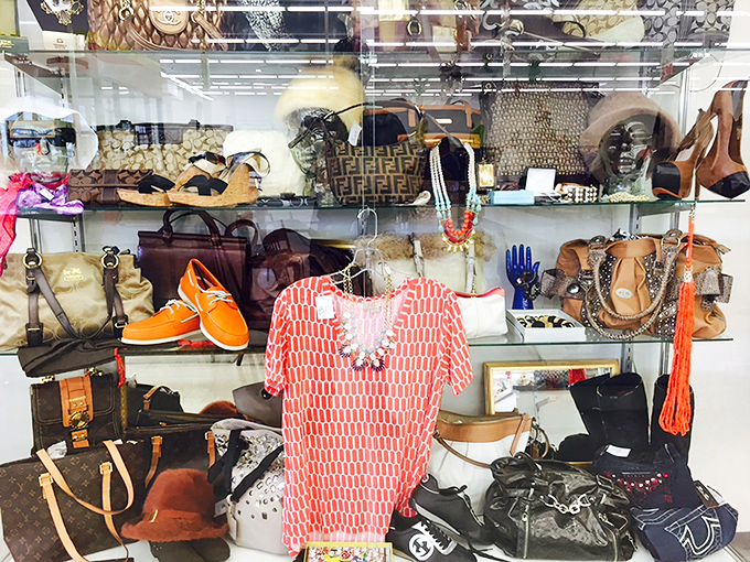 Designer bags and bright accessories behind glass—the thrift store's version of a museum display, but you can actually take these home.