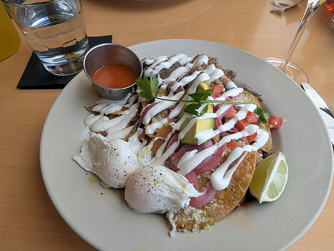 Chilaquiles with poached eggs that break like sunrise over tortilla mountains. That crema drizzle is pure breakfast architecture.