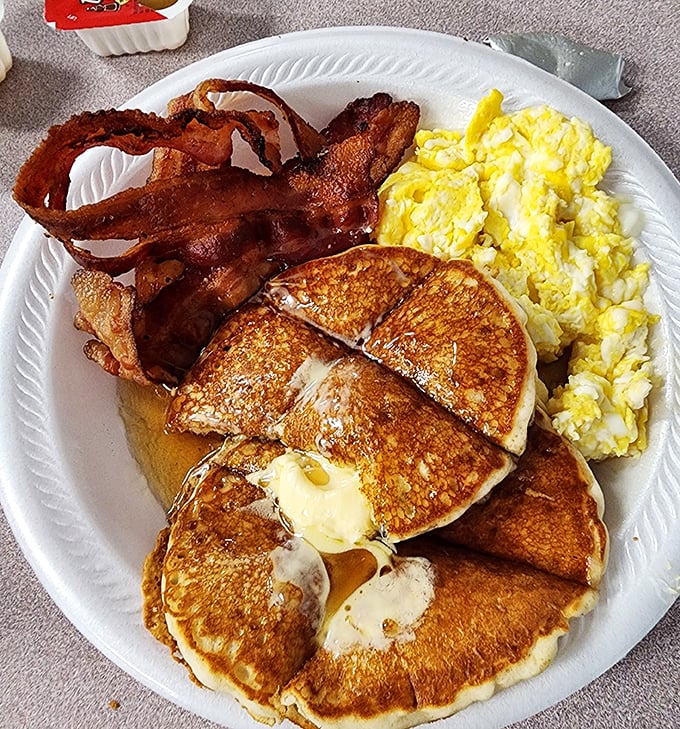 Breakfast perfection: golden pancakes with melting butter, eggs that know exactly what they're doing, and bacon that makes you question all other bacon.