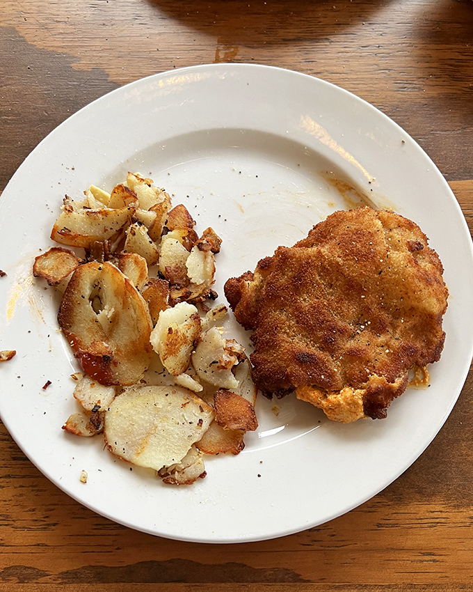 Golden-brown perfection meets crispy potatoes. This isn't just a cutlet—it's an edible postcard from Bavaria that says "Wish you were eating this."