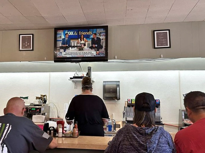 The breakfast counter ballet—customers perched on stools watching the news while staff orchestrate the morning rush with practiced precision.