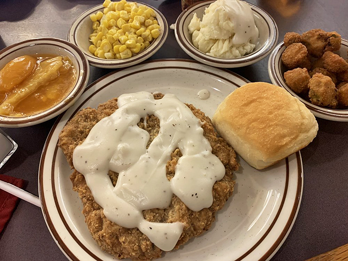 Country fried steak swimming in cream gravy – proof that sometimes the most beautiful things in life aren't meant to be photographed, just devoured.