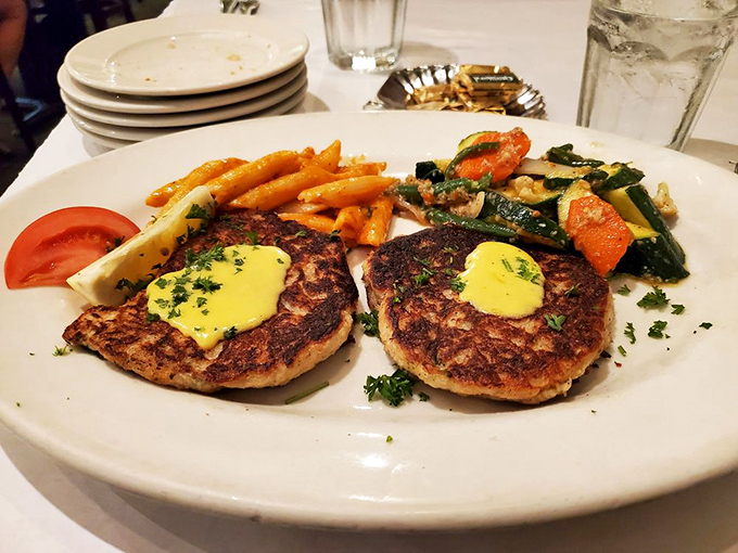 These golden-brown crab cakes with their dollop of sauce aren't just appetizers—they're discs of maritime happiness.