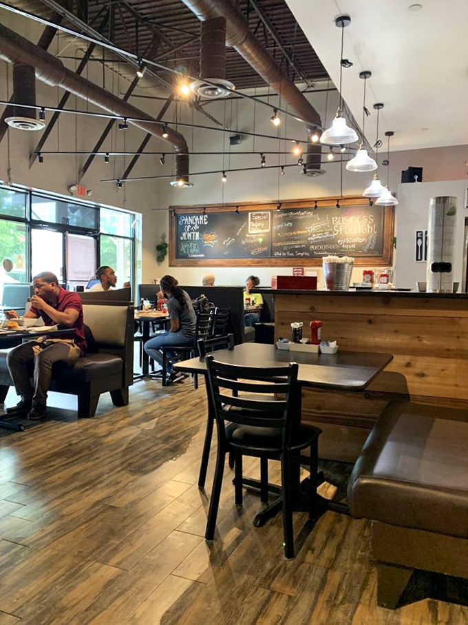 Morning conversations and coffee refills flow freely in this warm space. The exposed ceiling and pendant lights create an atmosphere where lingering is encouraged.