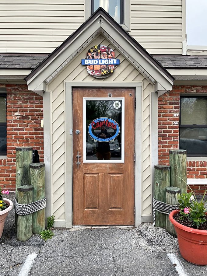 This welcoming entrance promises authentic Maryland flavors just beyond that weathered wooden door and brick facade.