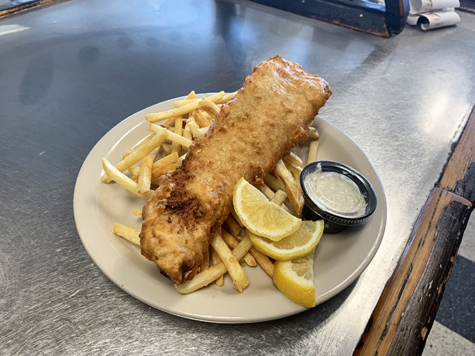 Fish and chips that would make a British pub proud—golden batter shattering at first bite, with fries standing by for sauce duty.