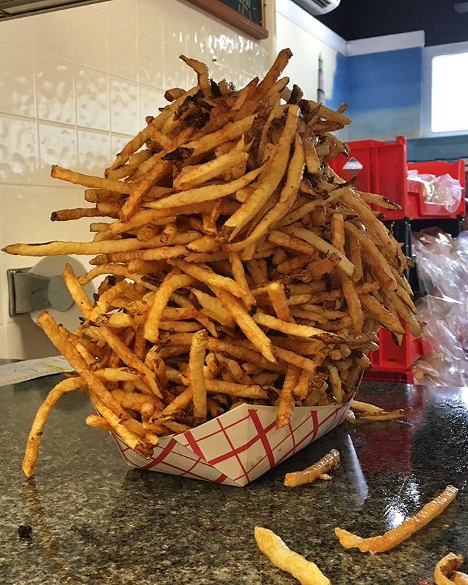 The French fry tower of power—crispy, golden, and stacked higher than your weekend to-do list. Worth every carb-laden bite.