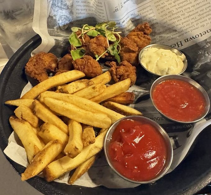 Fried perfection served newspaper-style—because good food doesn't need fancy plates. Those dipping sauces are about to become your new best friends.