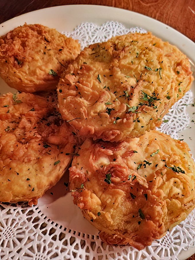 Fried green tomatoes that could make your grandmother both jealous and proud. Crispy, tangy perfection on a doily—because some traditions matter.
