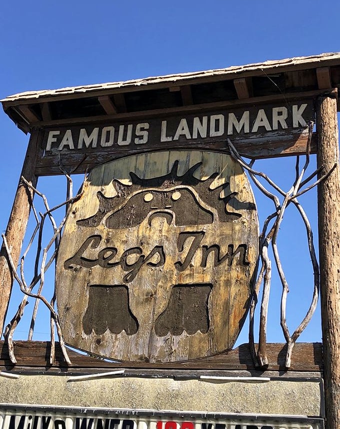 Famous Landmark indeed—where else does a sun-weathered wooden sign featuring upside-down stove legs become an iconic northern Michigan beacon?