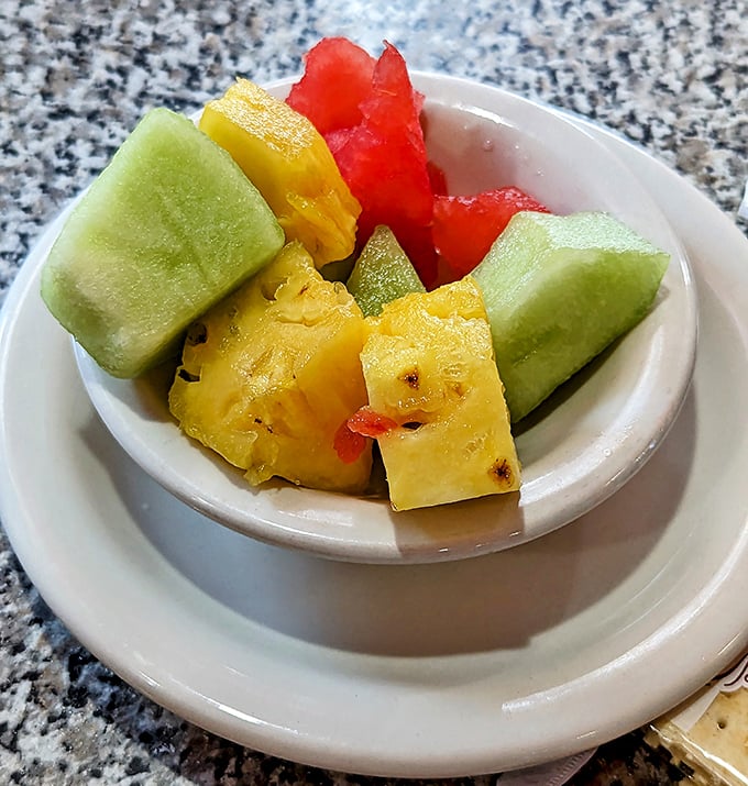 Fresh fruit appears like a colorful apology for the decadence that preceded it—a sweet reminder that balance is technically possible here.